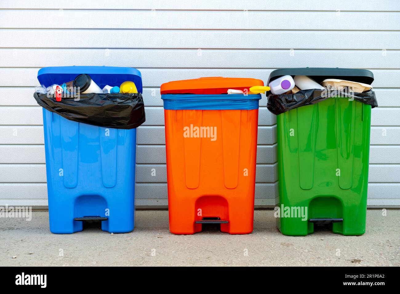 Three trash containers full of garbage near the building Stock Photo ...