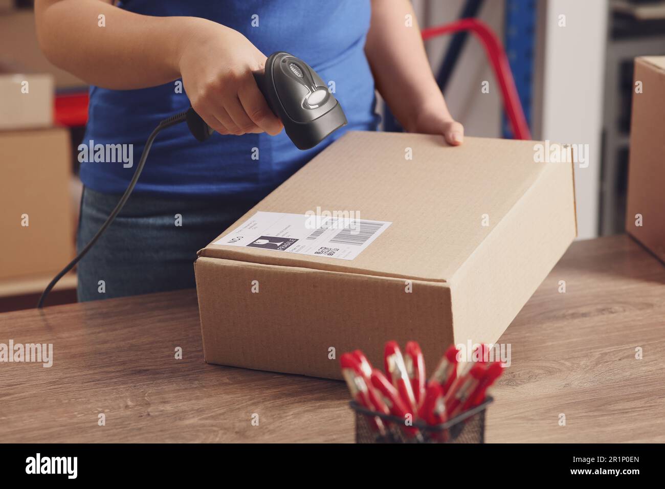 Post office worker with scanner reading parcel barcode at counter ...