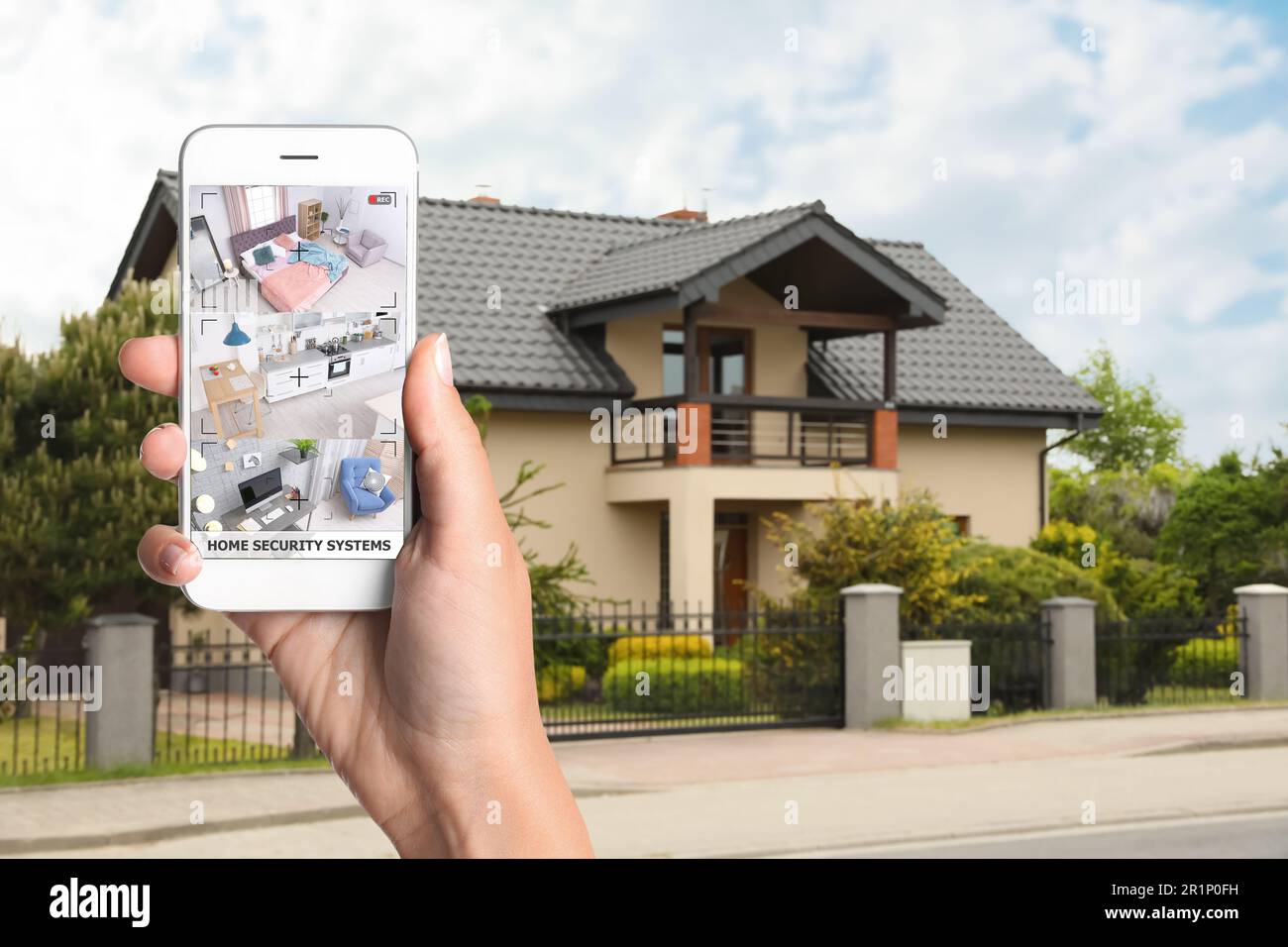 Home security system. Woman monitoring CCTV cameras on smartphone near ...