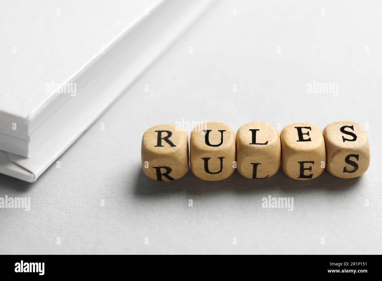 Word Rules made of wooden cubes with letters and book on white table ...