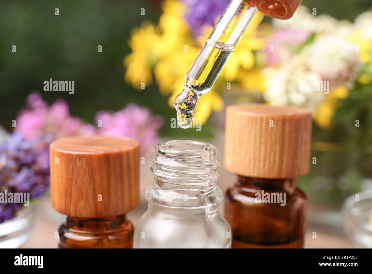 Dripping essential oil from pipette into bottle, closeup Stock Photo ...