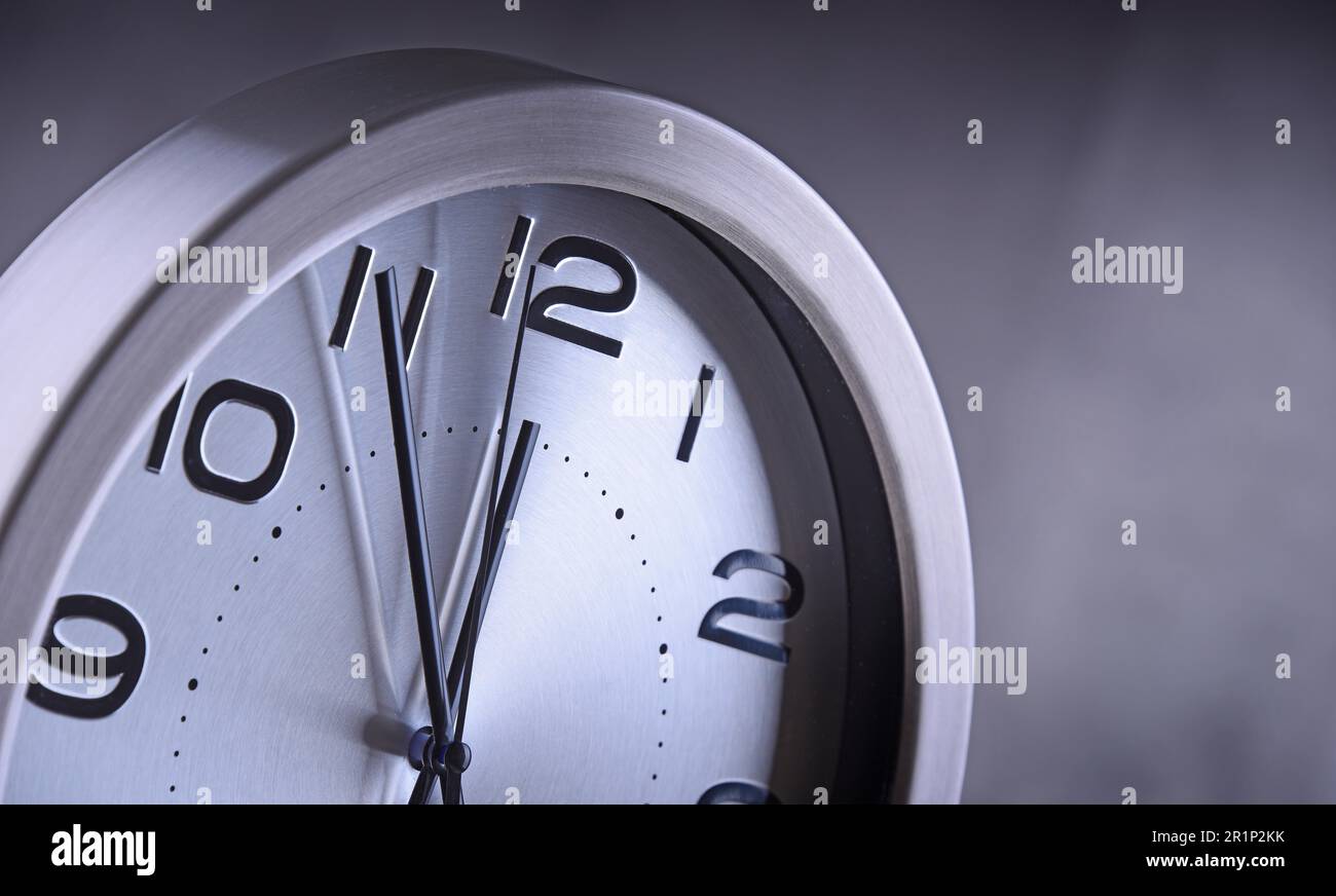 Modern wall clock showing five to twelve Stock Photo - Alamy