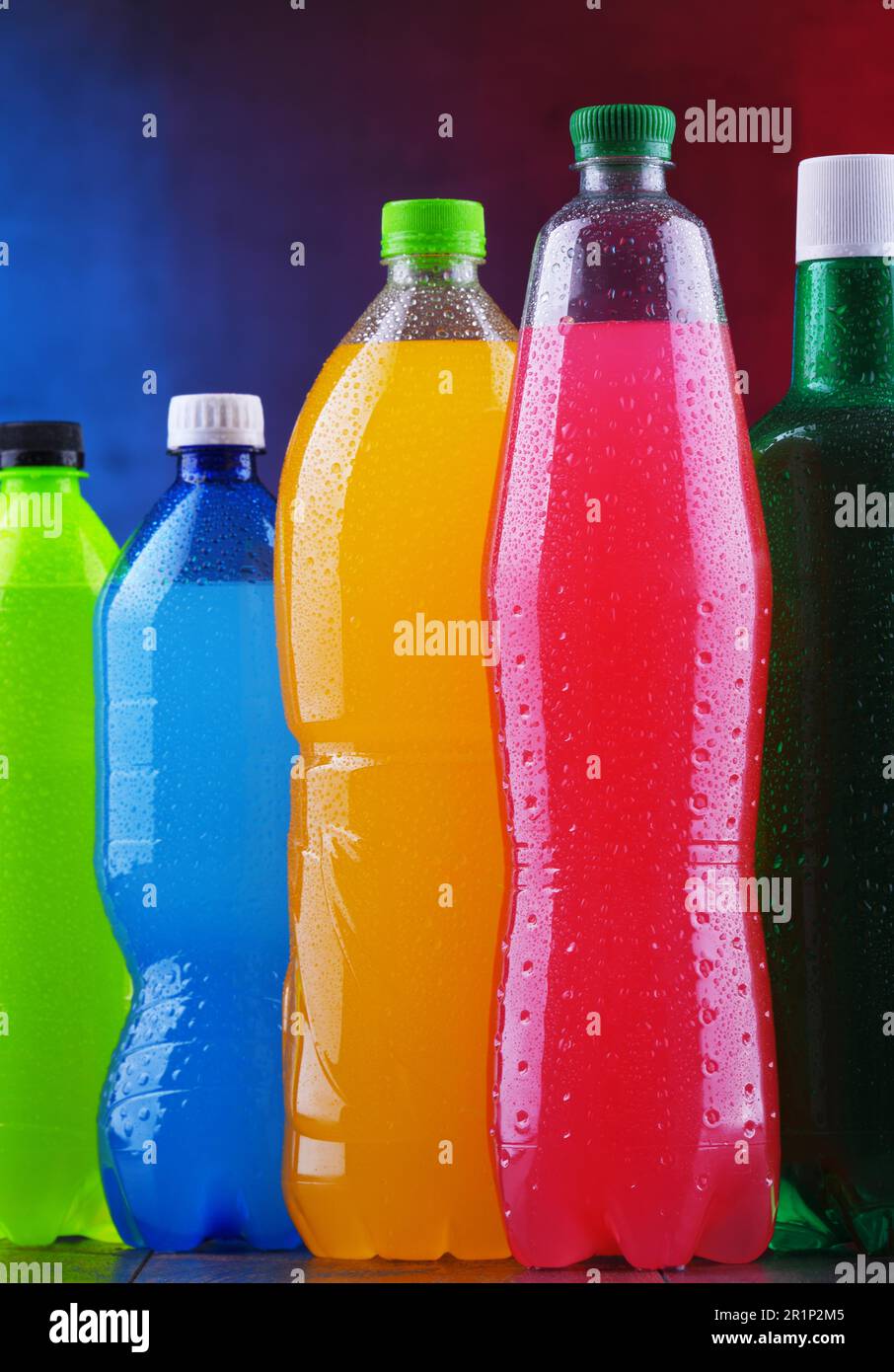 Plastic bottles of assorted carbonated soft drinks in variety of colors ...
