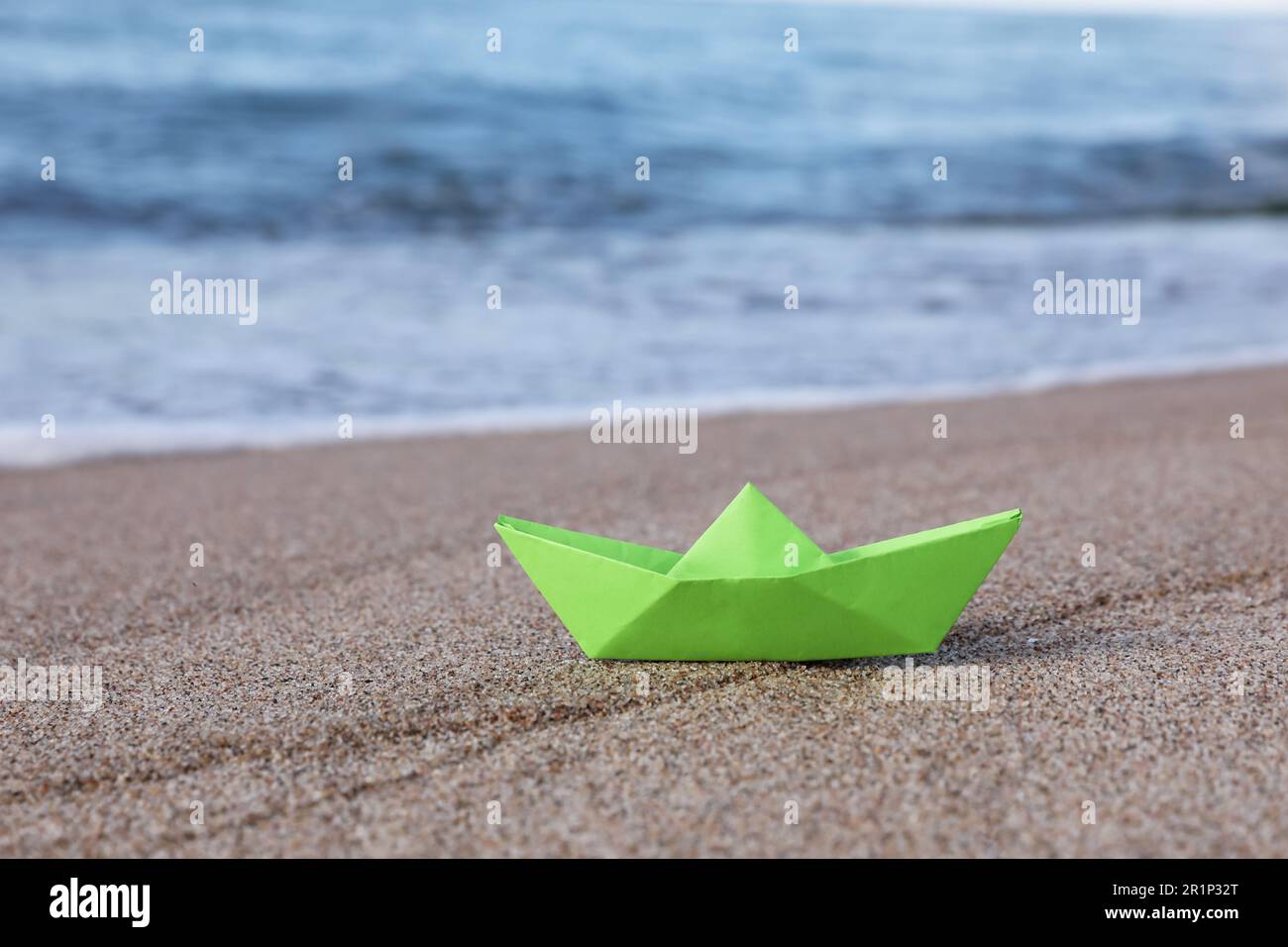 Light green paper boat near sea on sandy beach Stock Photo - Alamy