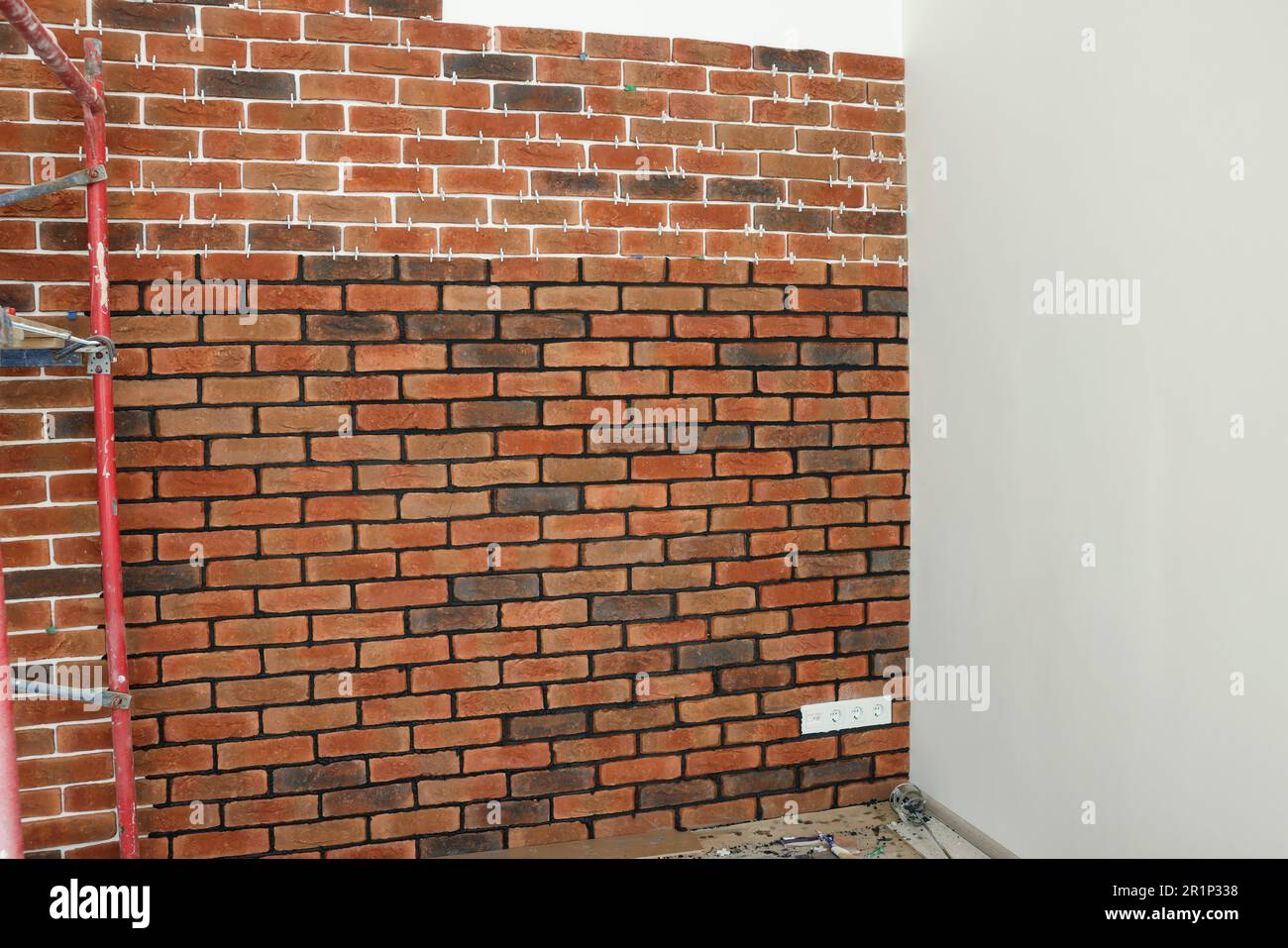 Decorative bricks with tile leveling system on white wall Stock Photo ...