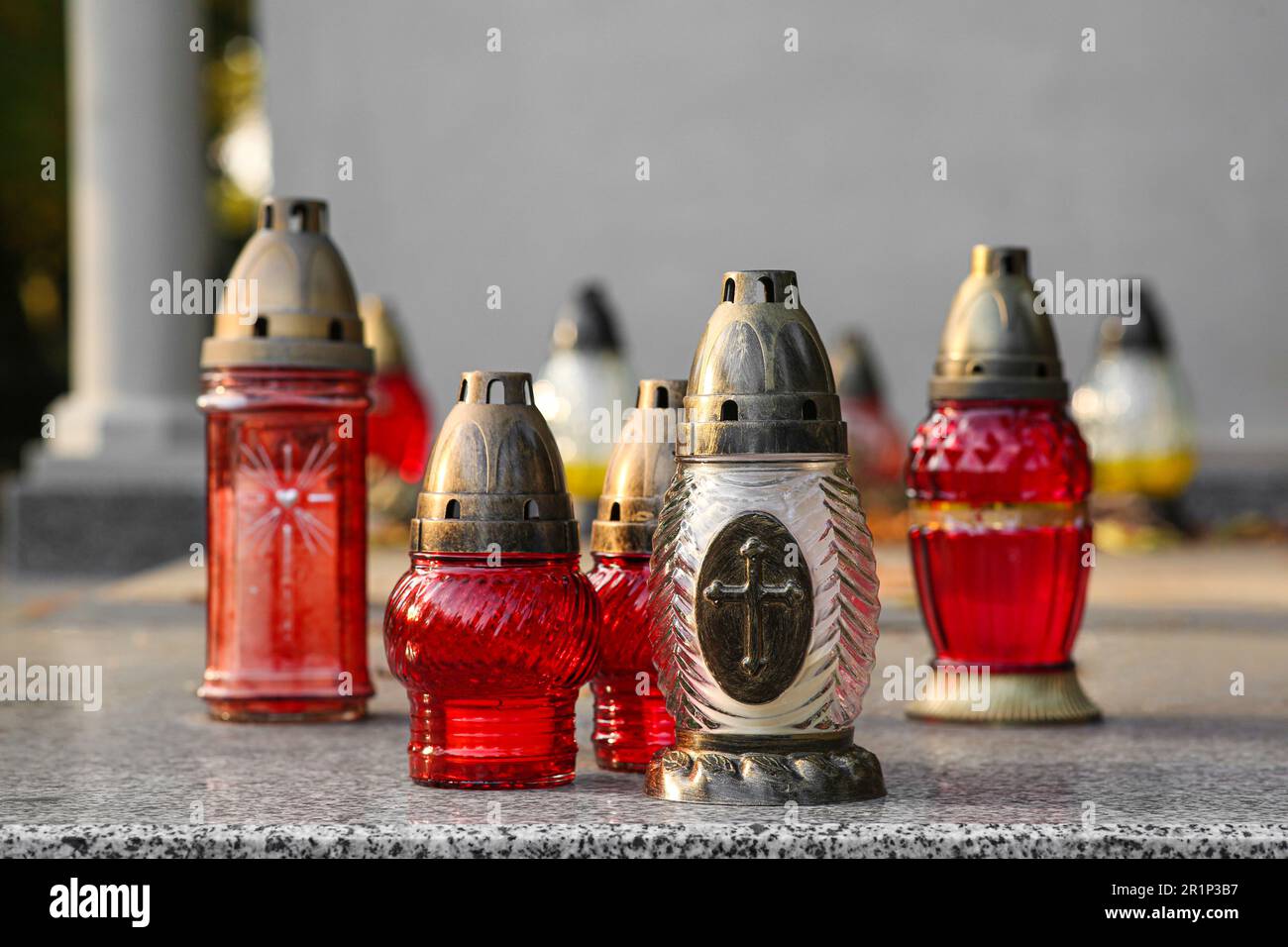 Different grave lanterns on granite tombstone outdoors. Funeral ceremony Stock Photo - Alamy