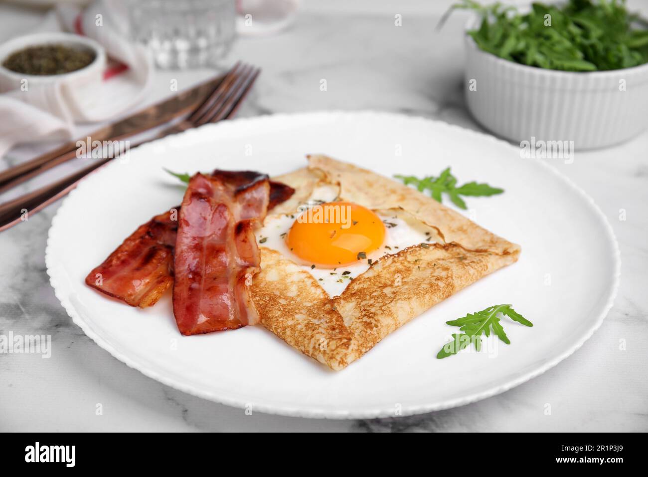 Delicious crepe with egg served on white marble table. Breton galette ...