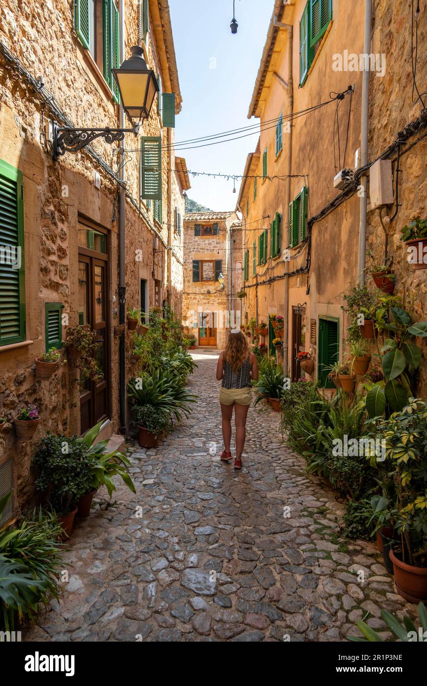 Tourist walking through alley, mountain village Valldemossa with ...