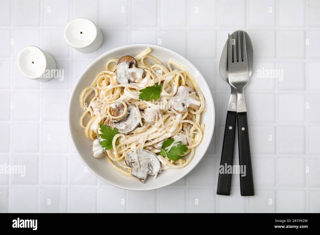 Delicious pasta with mushrooms served on white tiled table, flat lay ...