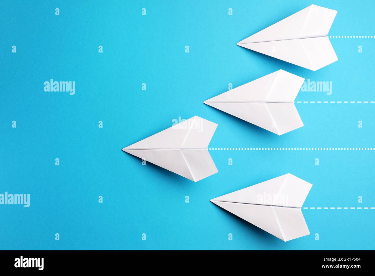 Handmade white paper planes on light blue background, flat lay. Space ...