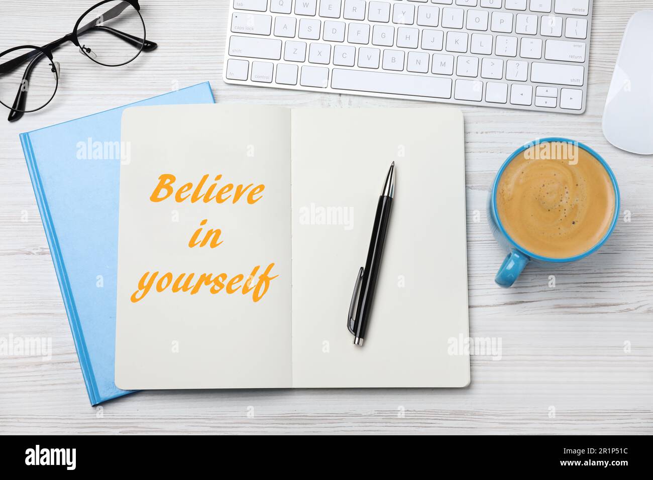 Phrase Believe in Yourself in notebook, computer keyboard and cup of ...