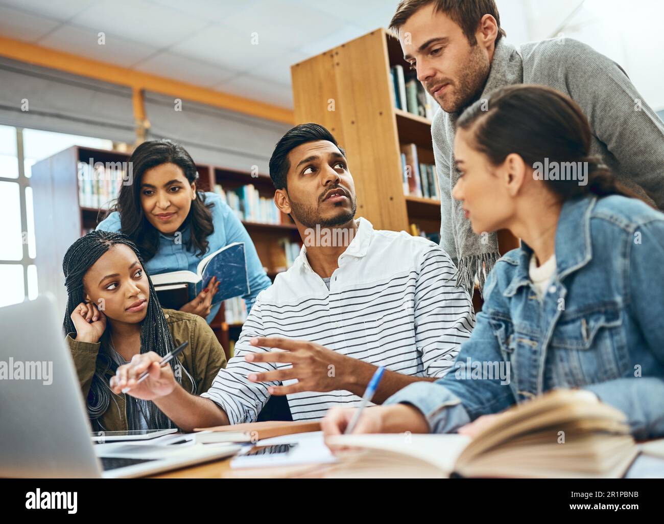 Education, talking and students studying in a library for a group ...