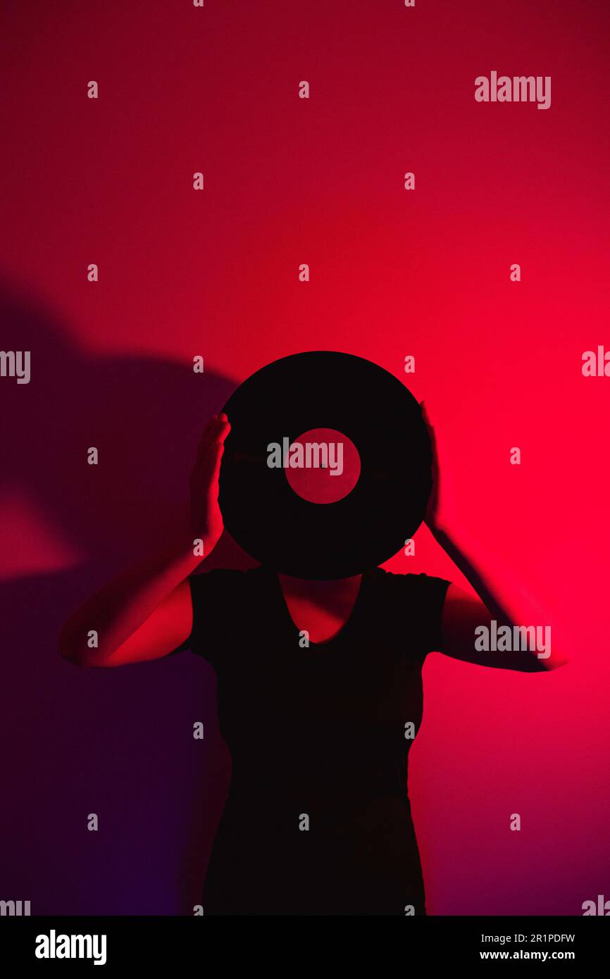 Woman holds record in front of her face, symbol 'music in the mind ...