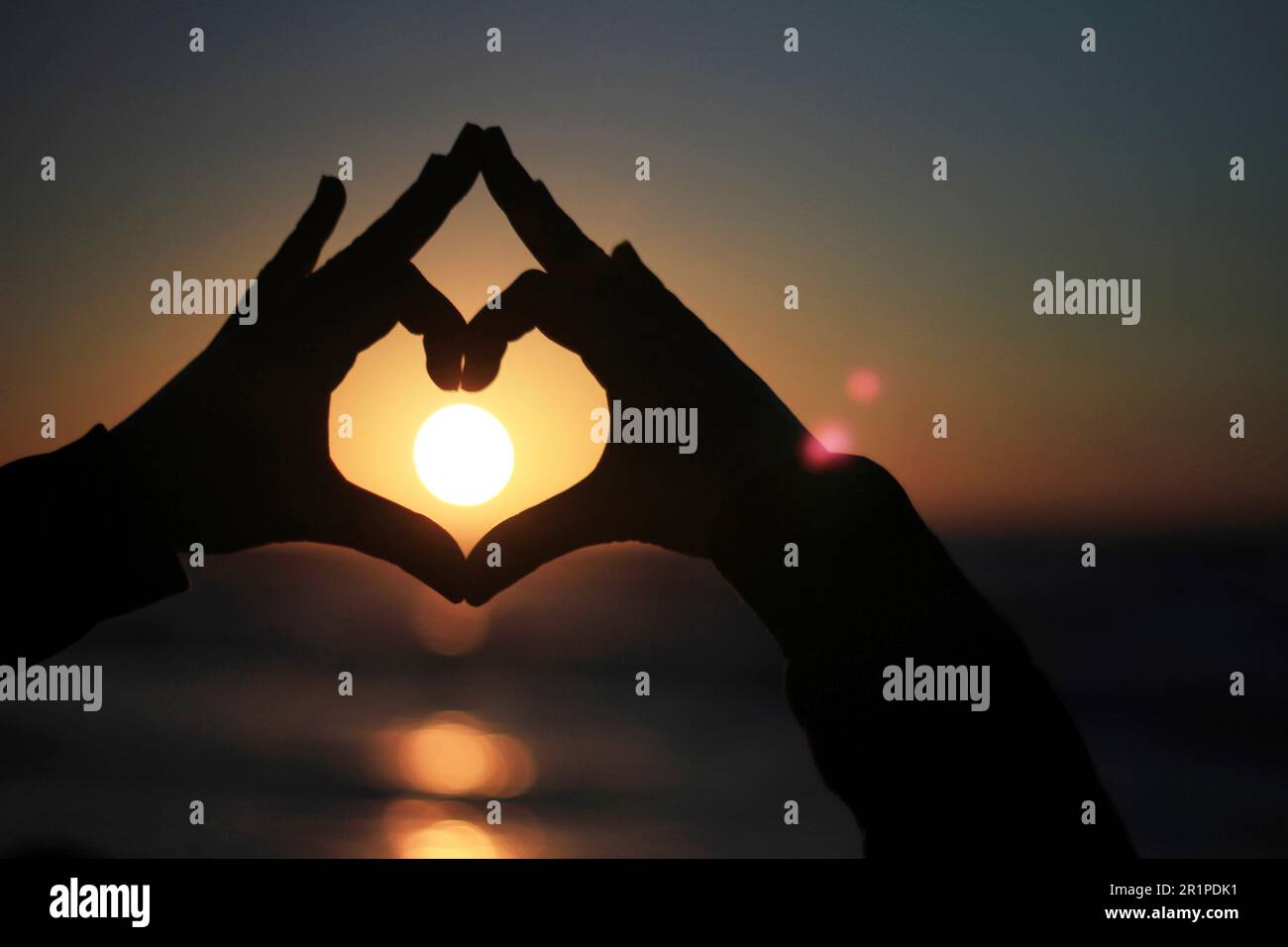 Hand, heart, sunset Stock Photo - Alamy