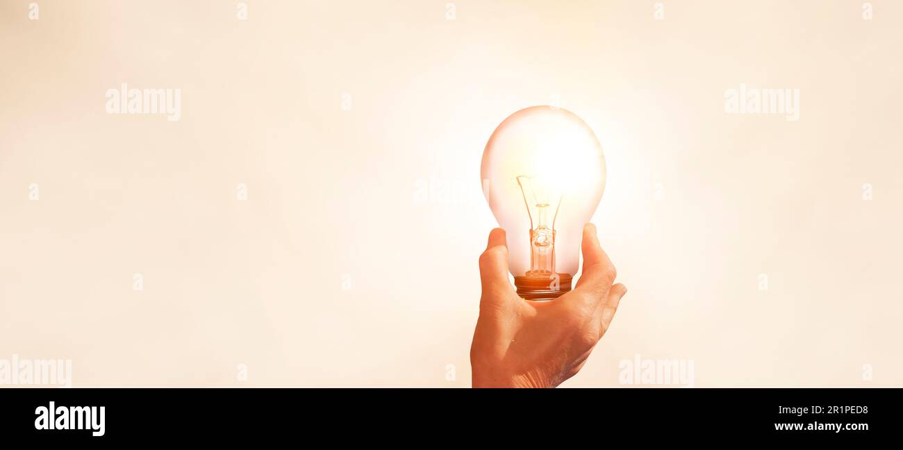 Hand holding a lighted bulb hi-res stock photography and images - Alamy