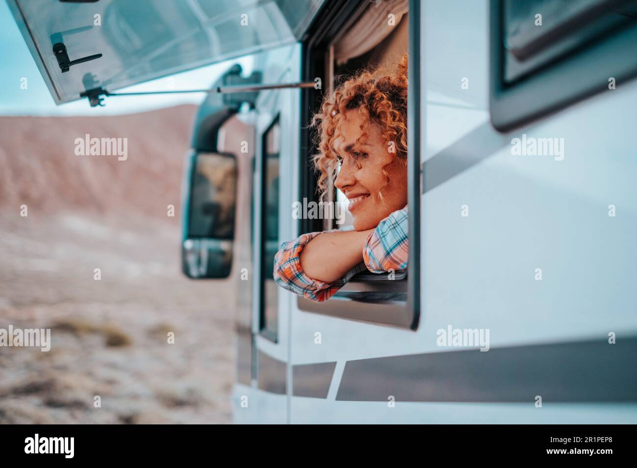 One female tourist enjoy view and freedom feeling inside a camper van ...