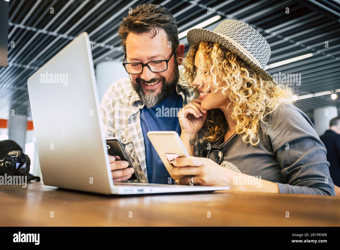Young millennial couple working together in coworking space with mobile ...