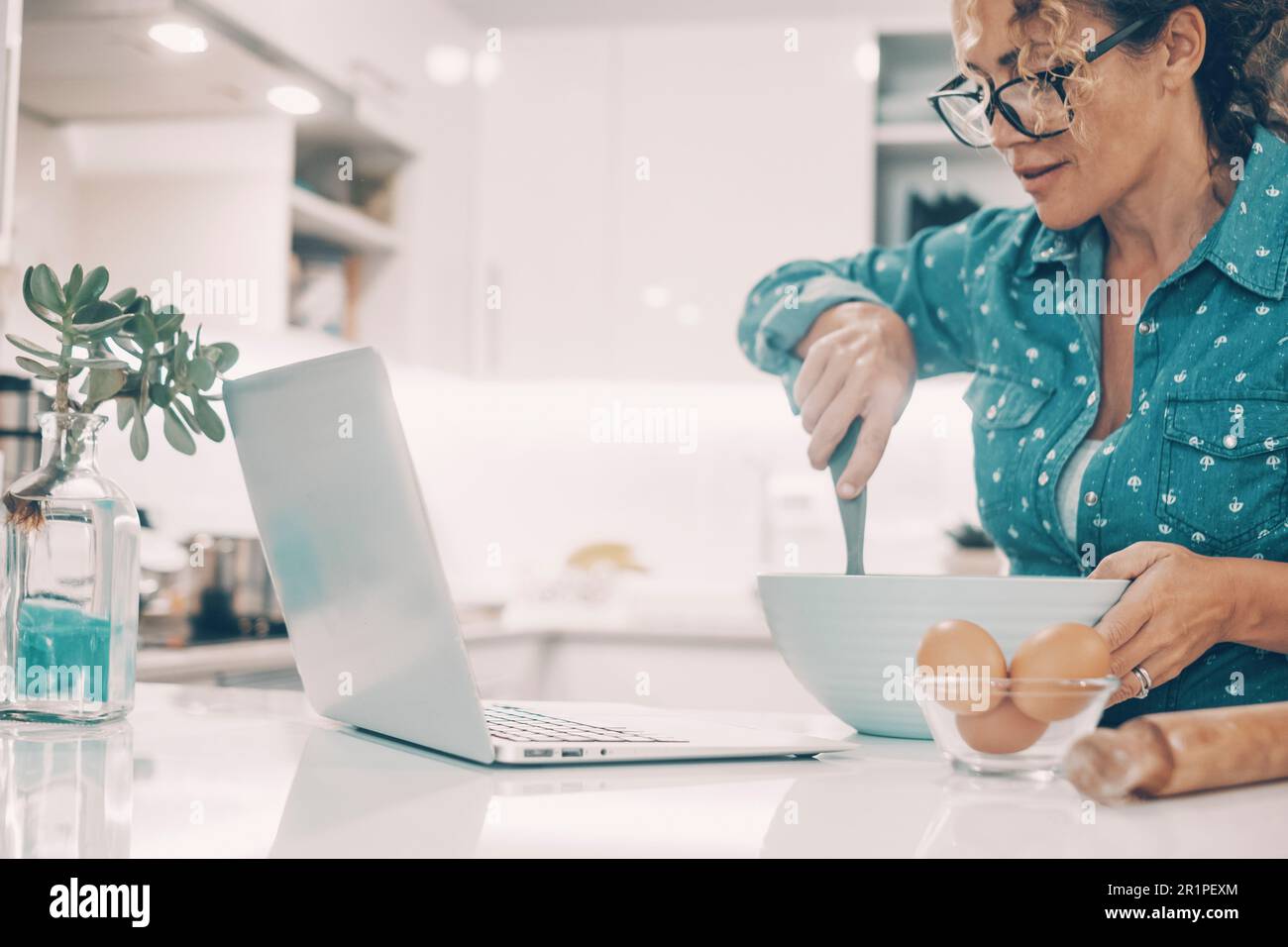 Happy adult woman cooking cake bakery at home watching tutorial ...