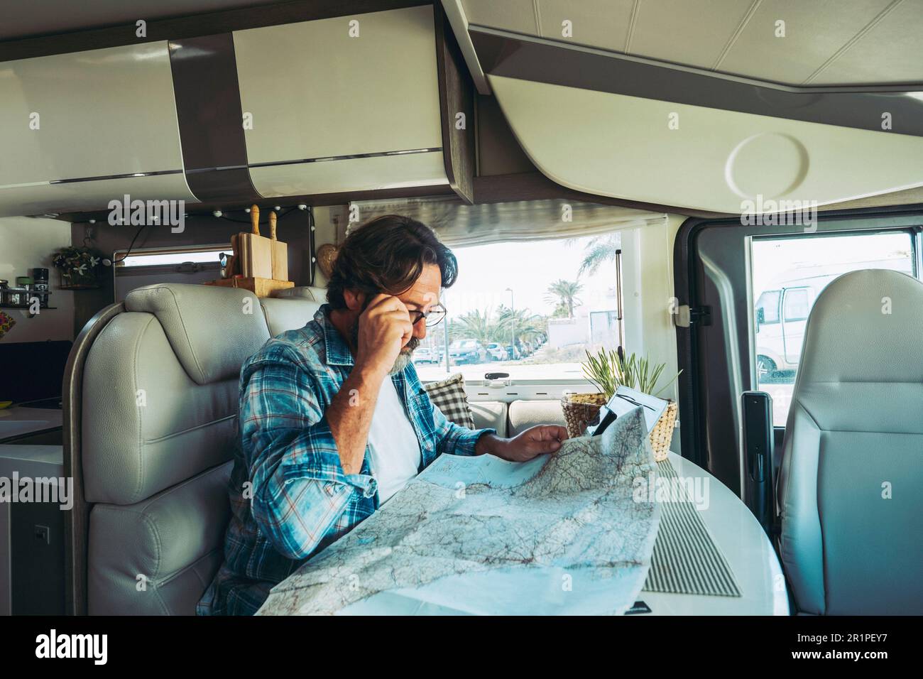 One traveler man alone inside a camper van looking for roads and ...