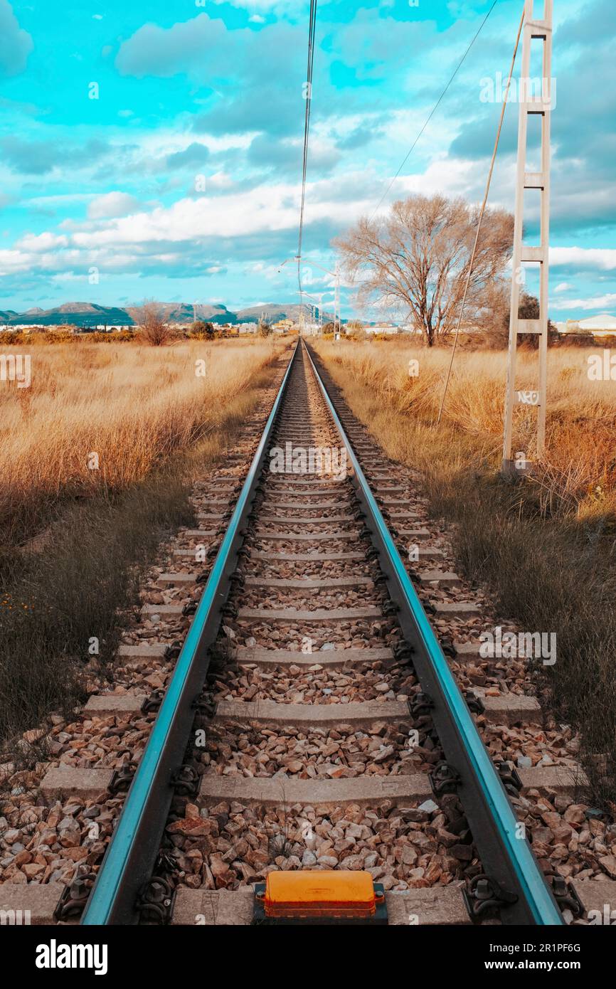 Empty railway in country side against a blue sky with clouds. Concept ...