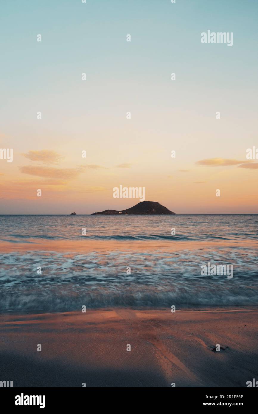 Vertical ocean sunrise landscape with island and colorful sky in ...