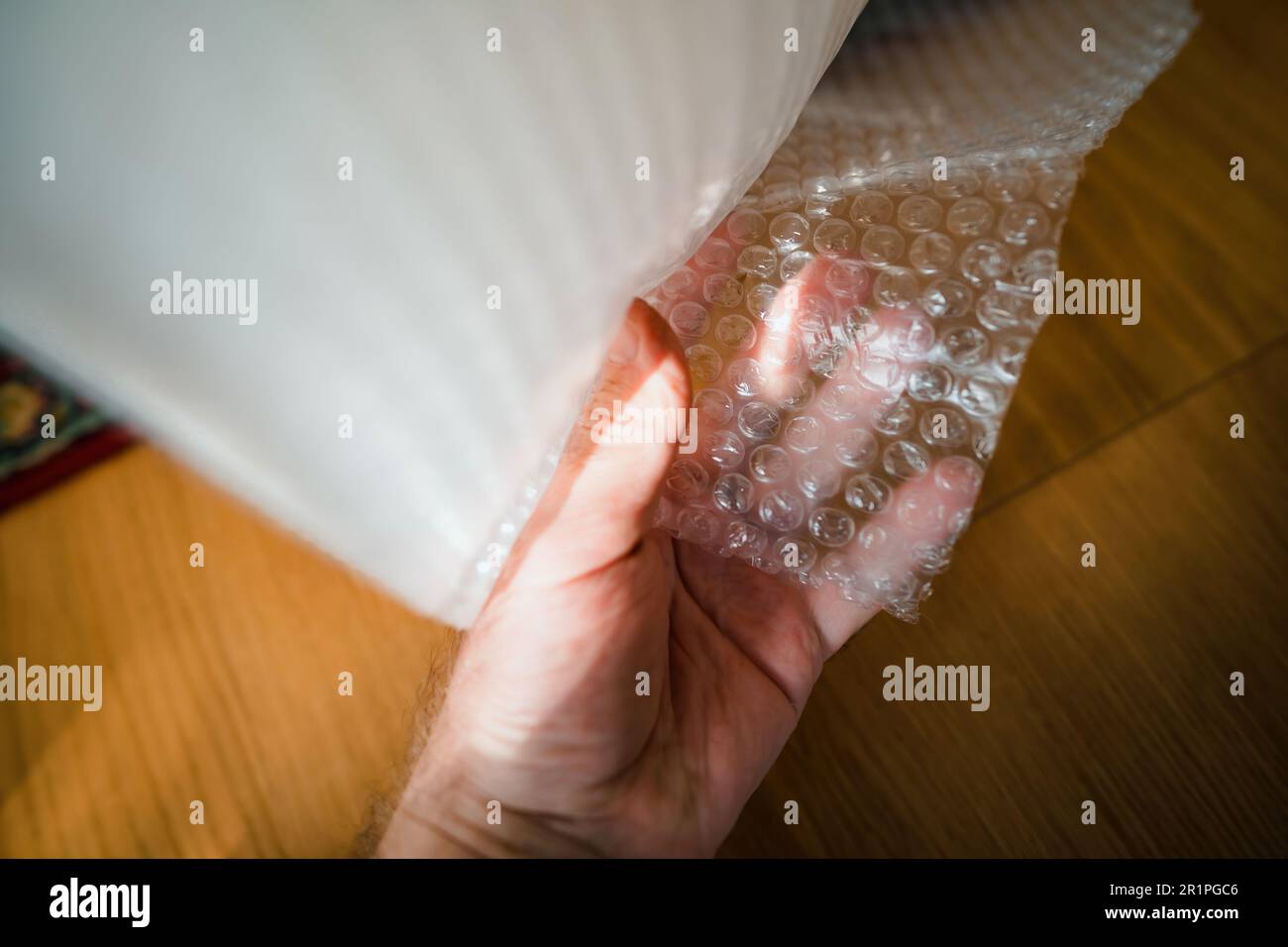 A man is carefully testing a giant roll of air-bubble packaging film ...