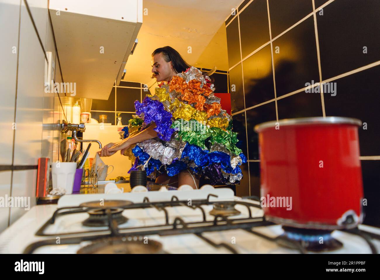 young latino gender non-binary person, dressed as a drag queen, at home ...