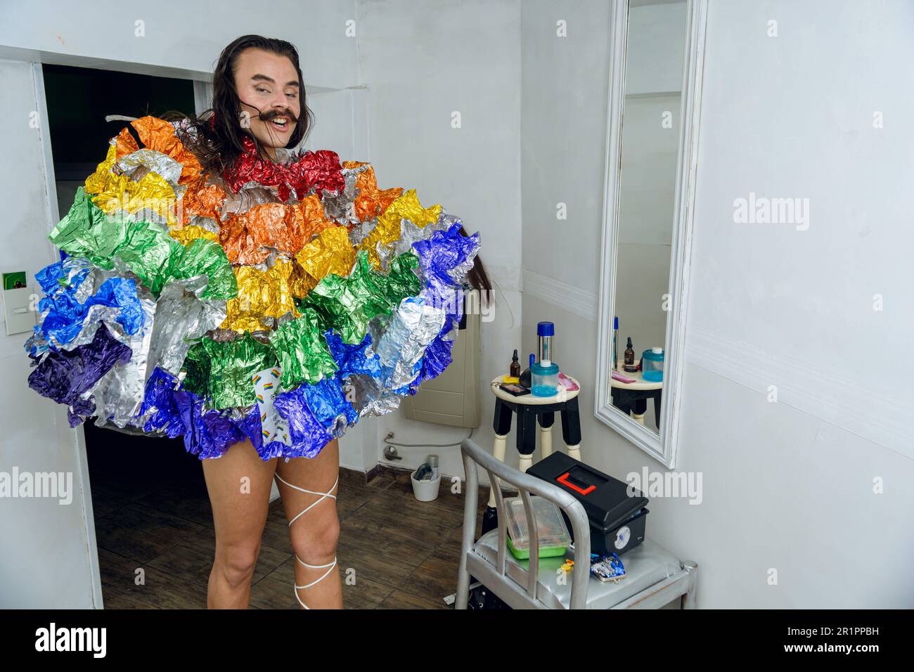 young person of gender non-binary drag queen standing in her room ...