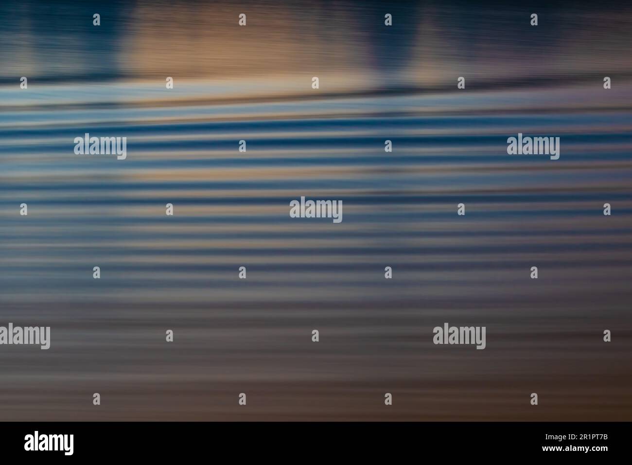 Evening light falling on water ripples producing abstract warm and cool ...