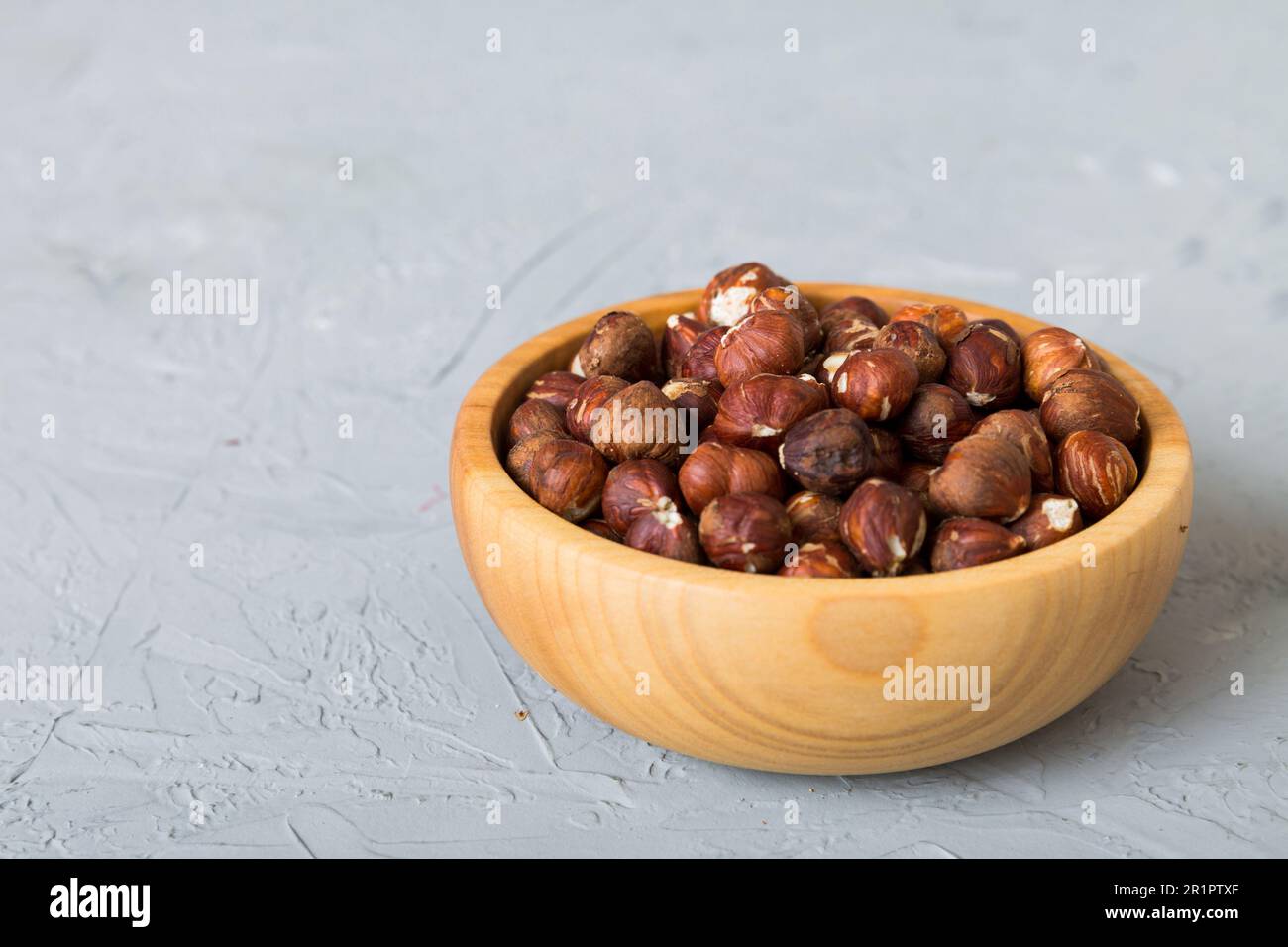 Wooden bowl full of hazelnuts on table background. Healthy eating ...