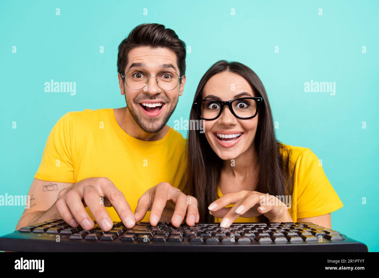 Photo of overjoyed funny excited nerd geeks writing keyboard looking ...