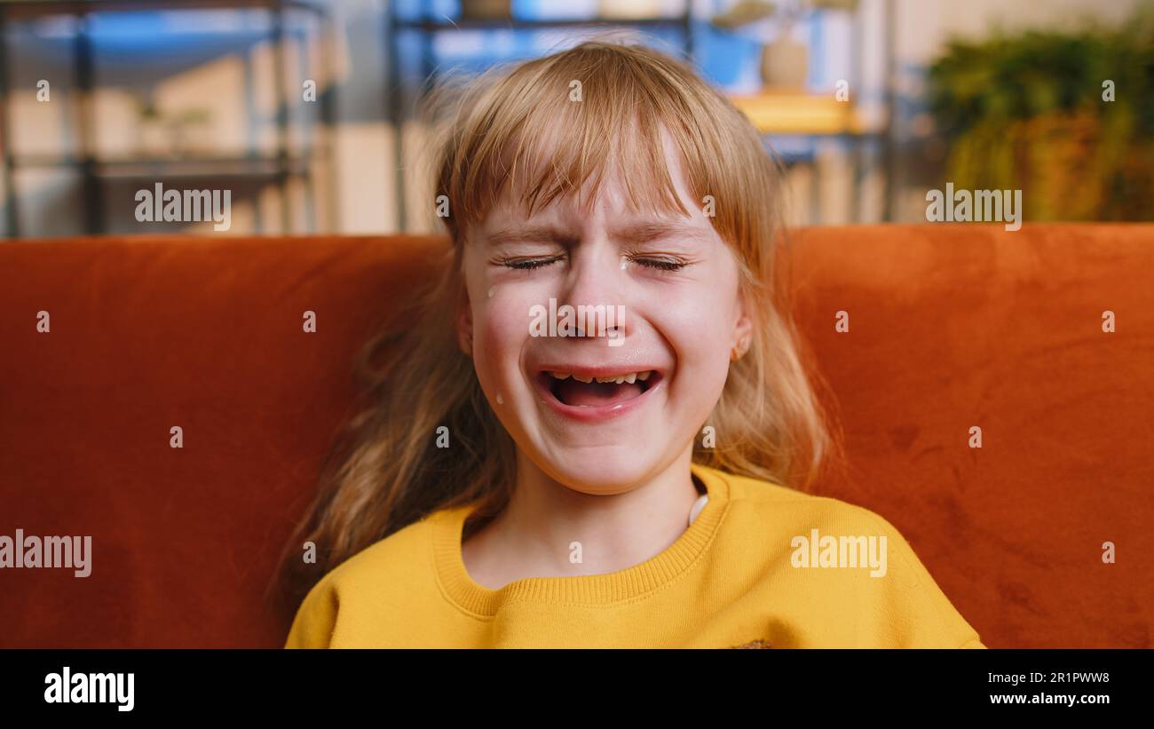 Close-up portrait of upset punished child little girl kid crying with ...