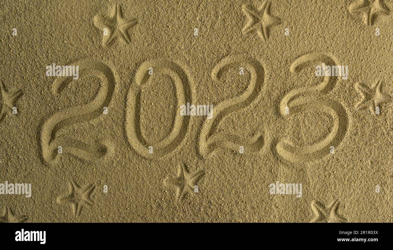 Signpost 2023 written in sand Stock Photo - Alamy