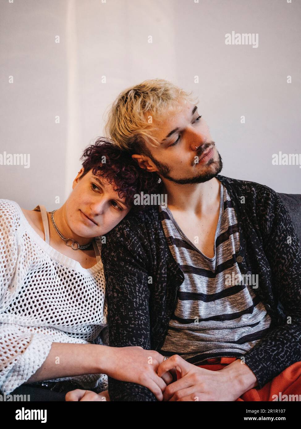 Non-binary couple on sofa Stock Photo - Alamy