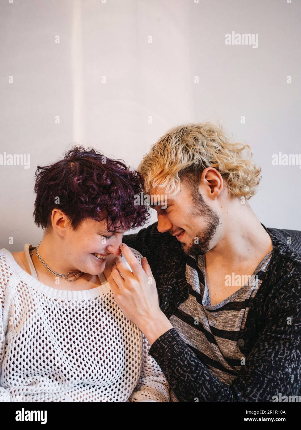 Non-binary couple on sofa Stock Photo - Alamy