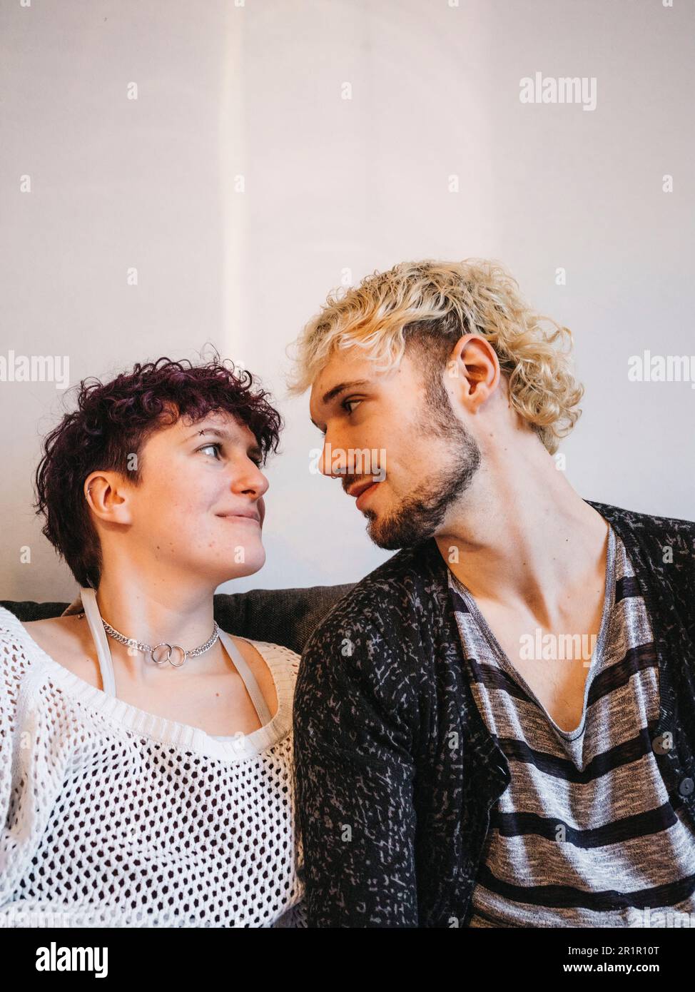 Non-binary couple on sofa Stock Photo - Alamy