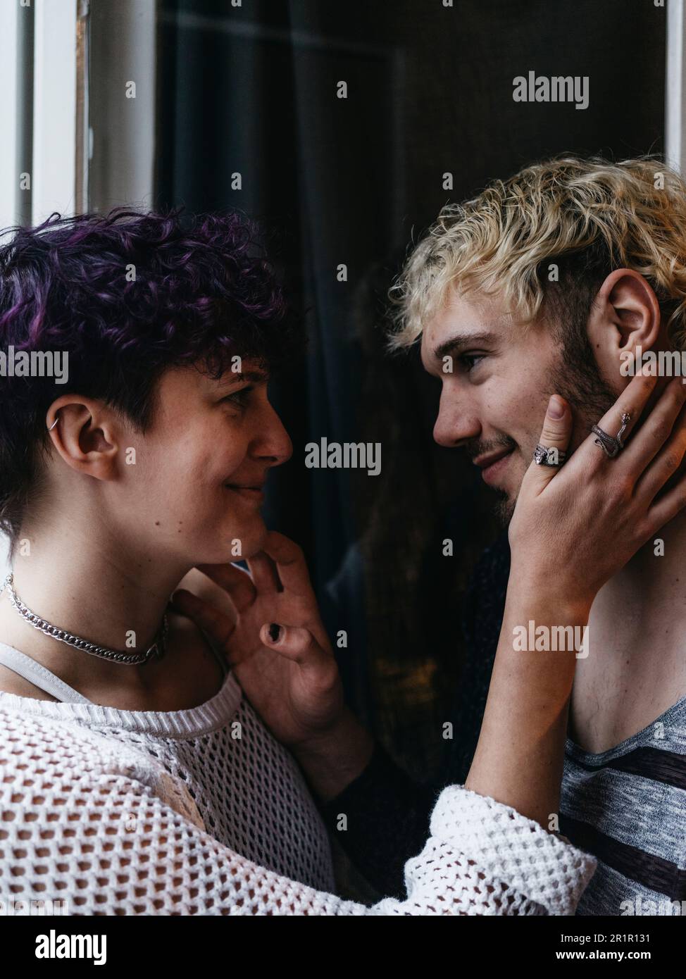 Non-binary couple at window Stock Photo - Alamy