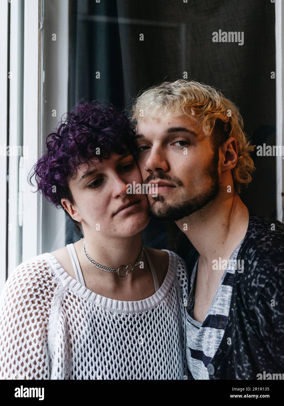 Non-binary couple at window Stock Photo - Alamy