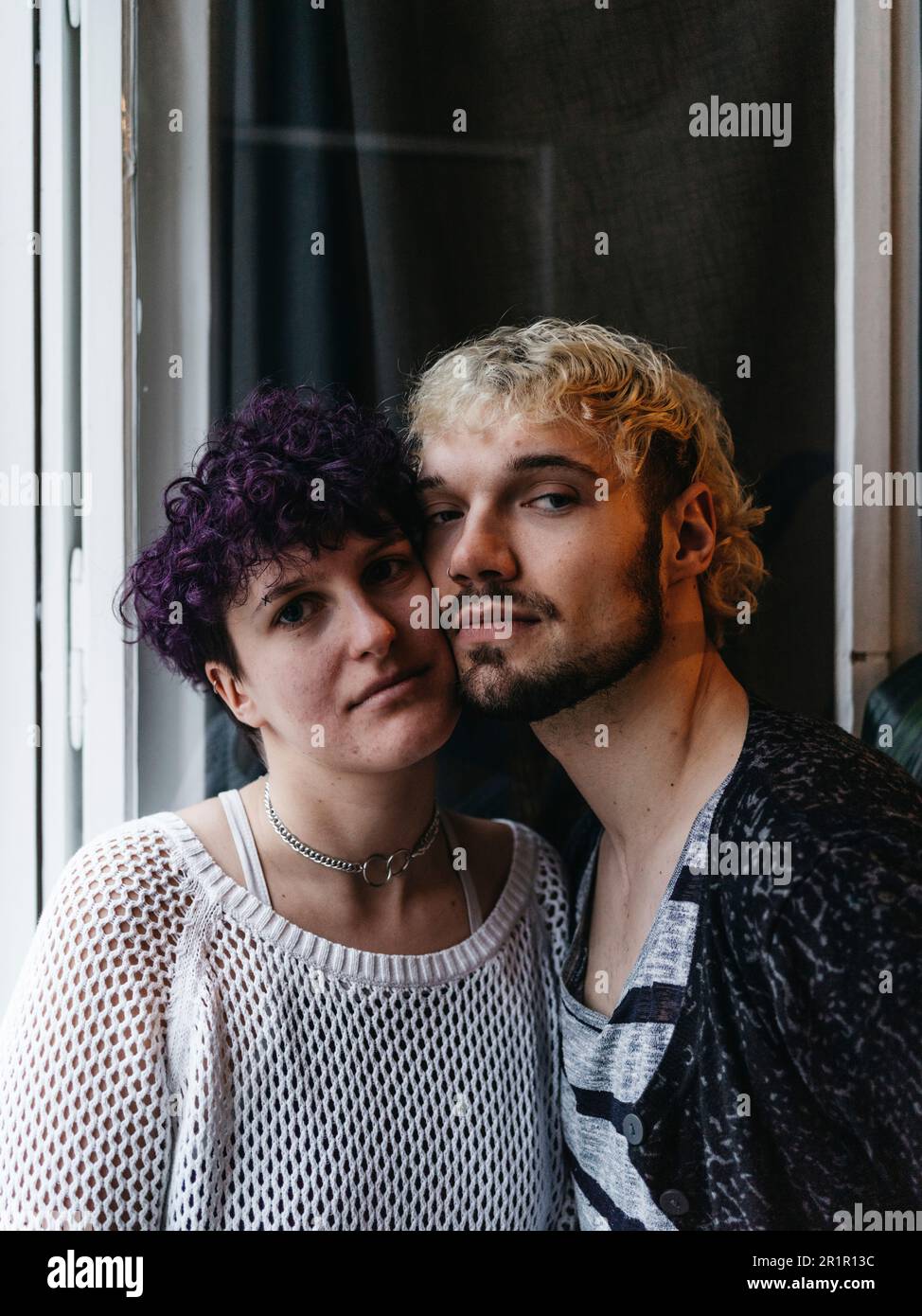 Non-binary couple at window Stock Photo - Alamy