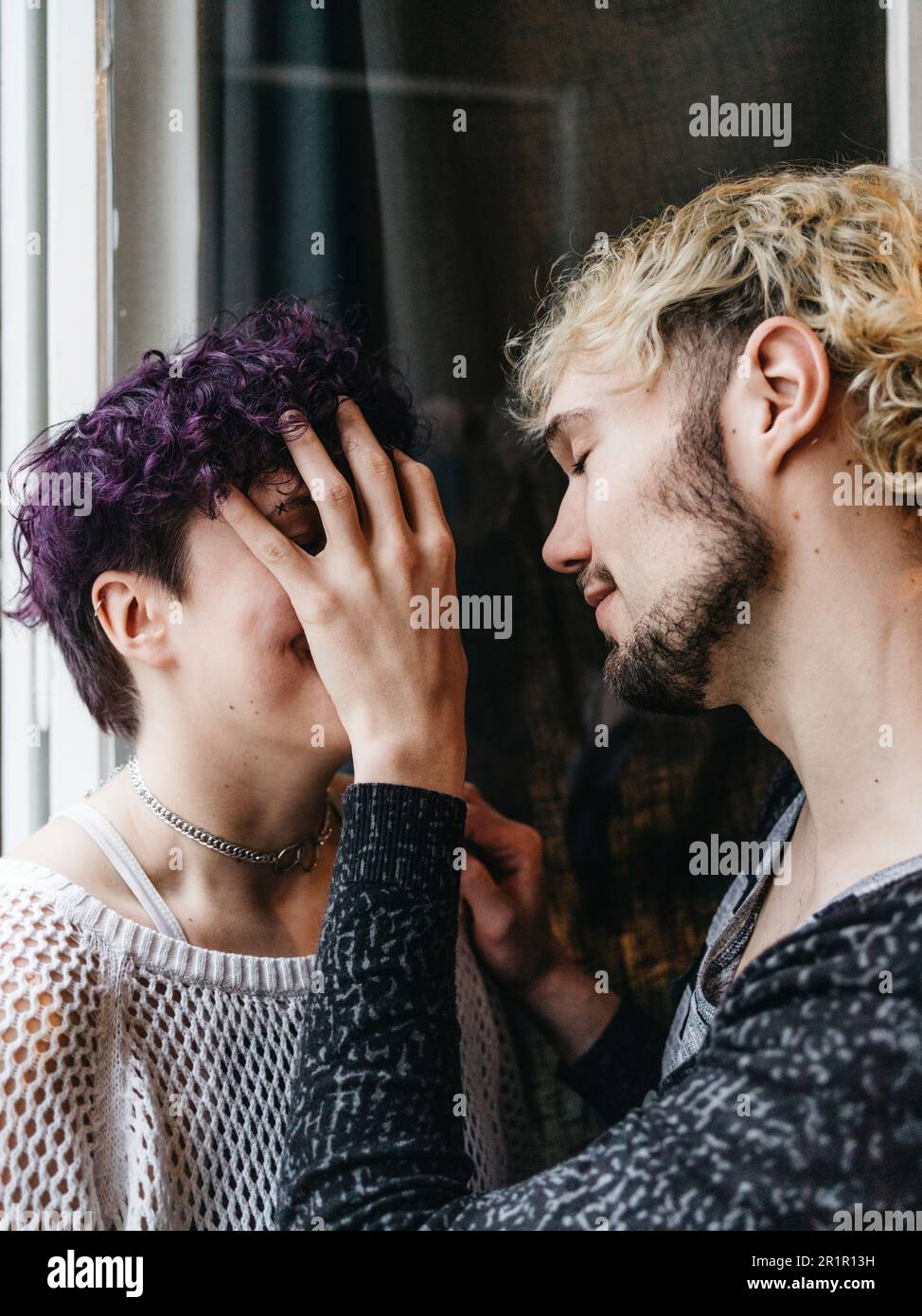 Non-binary couple at window Stock Photo - Alamy