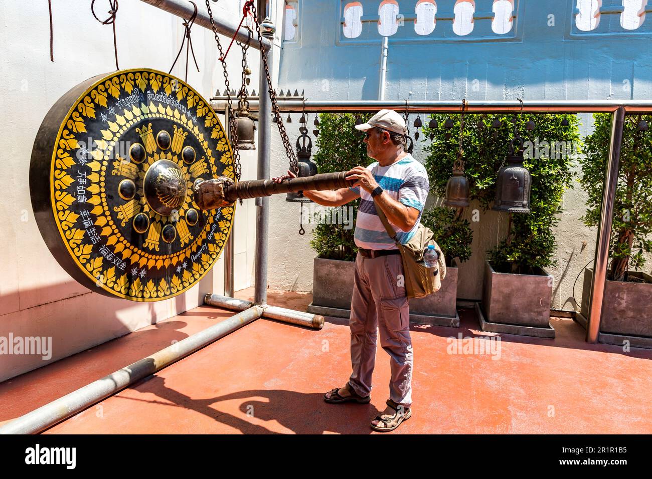 Tourist operates the prayer gong, prayer bells, Wat Saket, Temple of ...