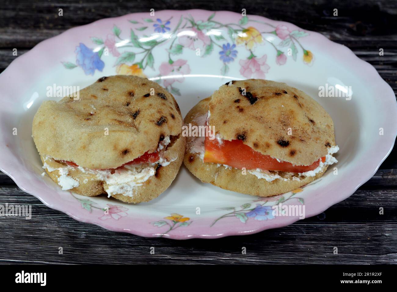 Feta white cheese with slices of tomatoes inside a mini traditional ...