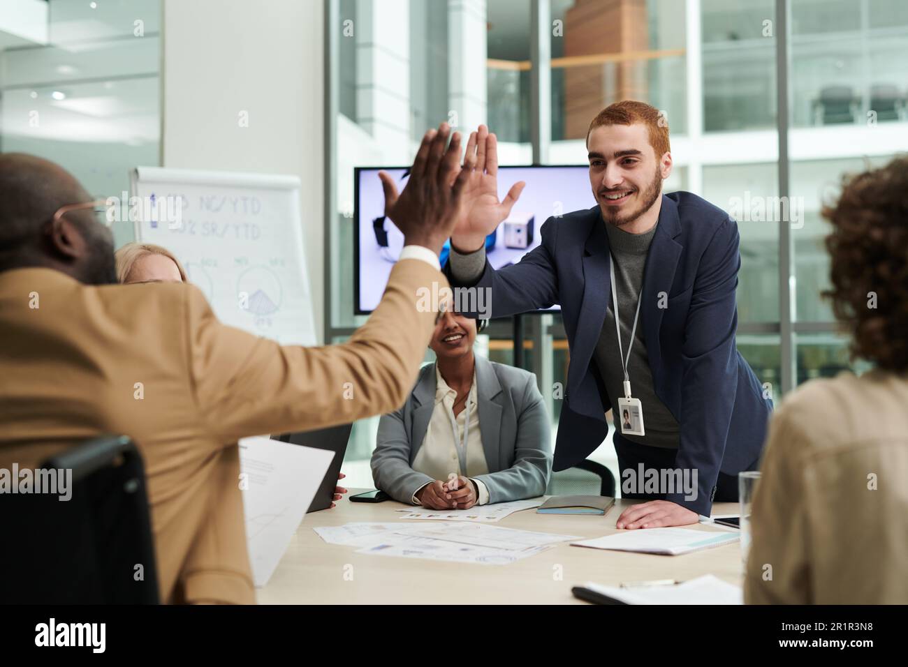 Young smiling businessman giving high five to African American ...