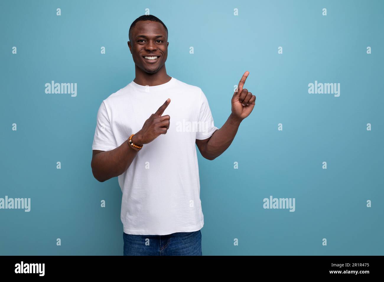 a handsome young american guy in a white t-shirt shows his hand to the ...