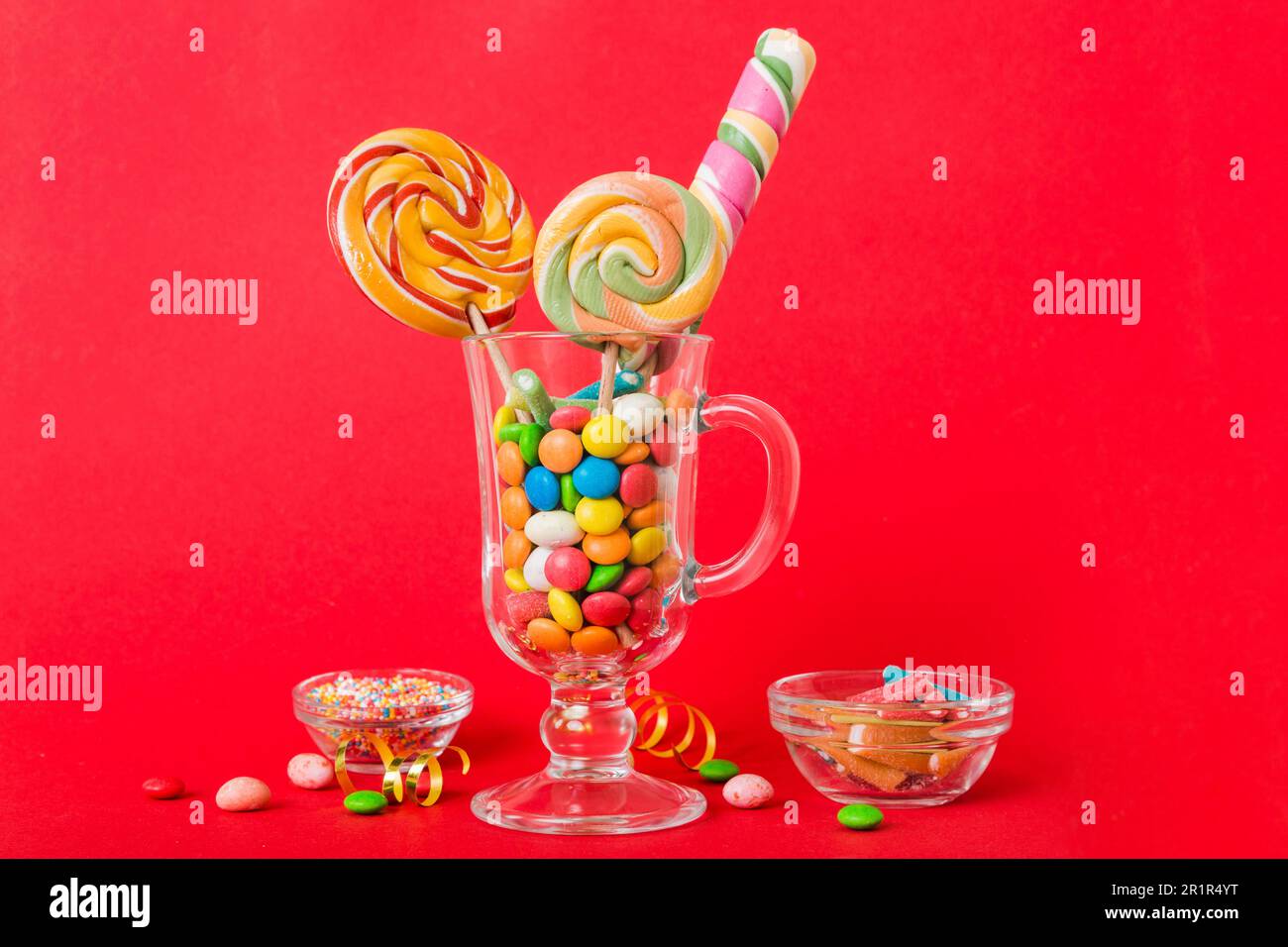 Colorful candies in cup on table on light background background. Large ...