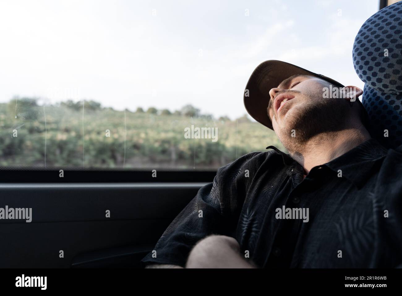 A young man is taking a nap during a bus trip Stock Photo - Alamy