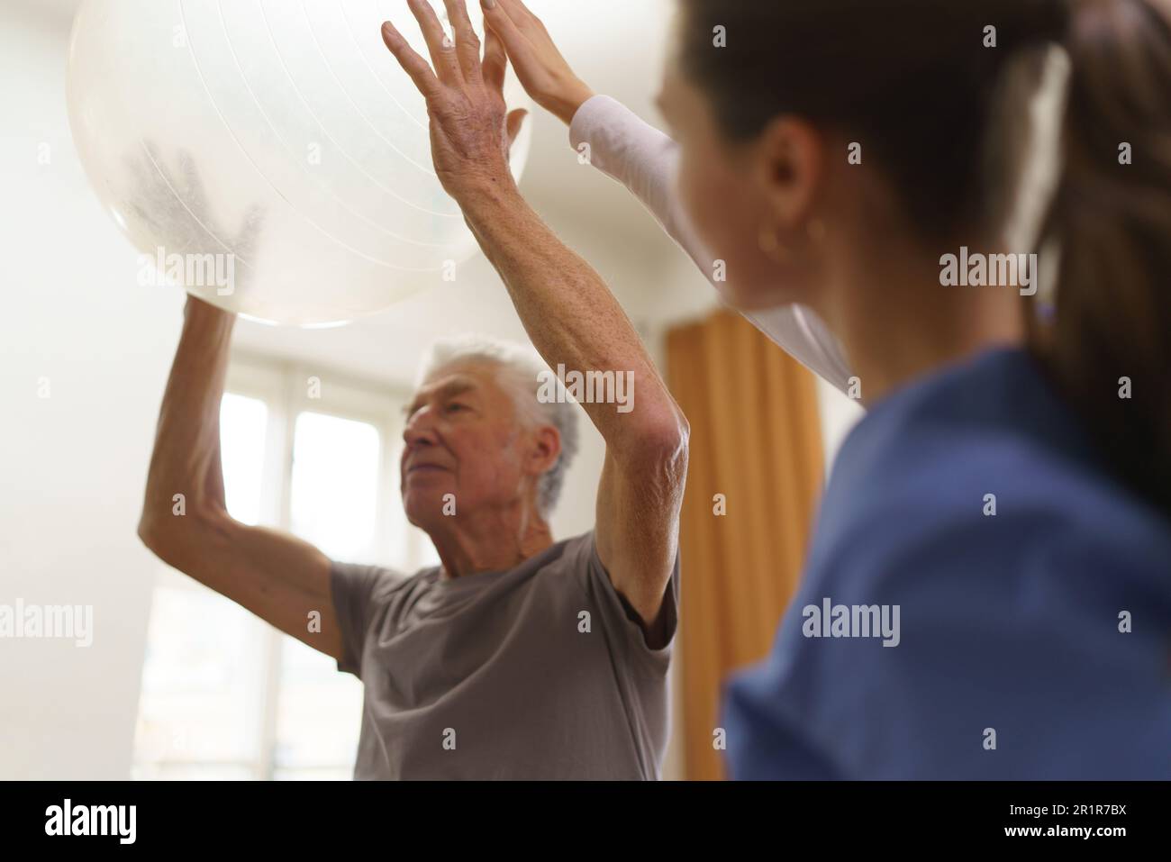 Young nurse doing exercise with senior man Stock Photo - Alamy