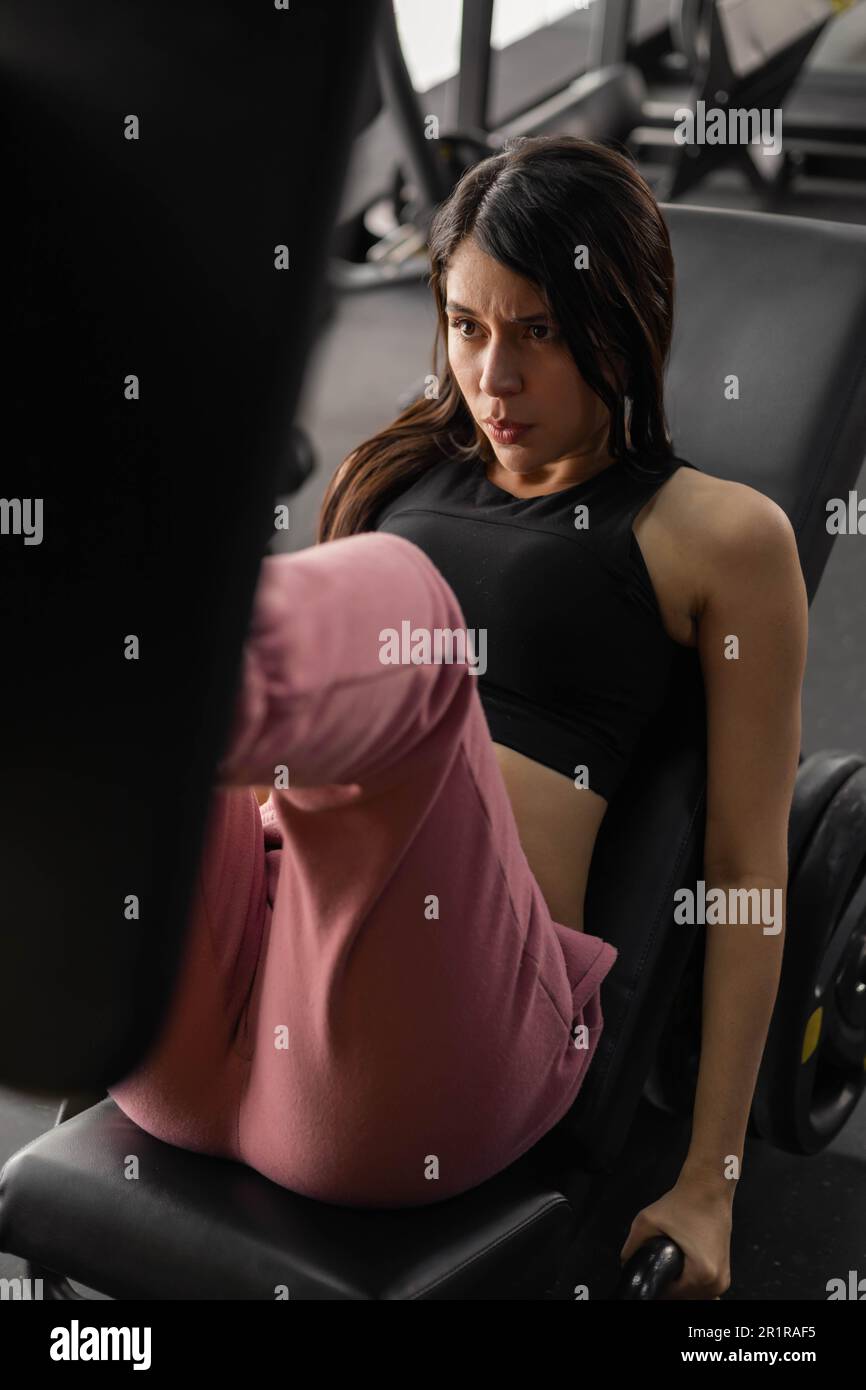 doing strength exercises with a gym machine, fitness training for legs ...