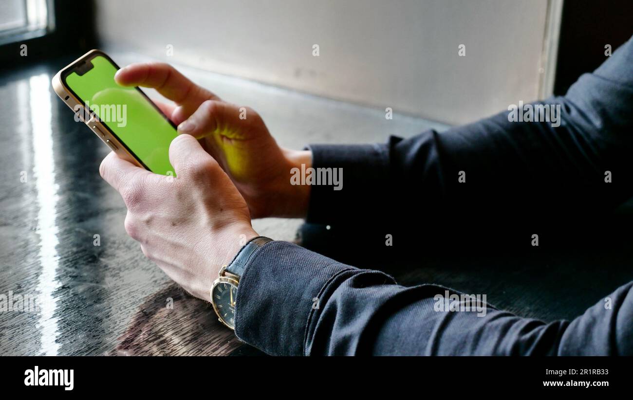 Close-up device smartphone with green screen in men's hands. A ...