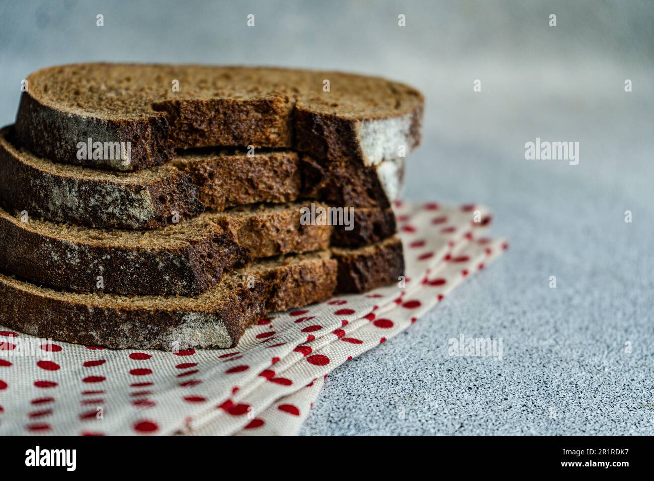 Stack of dark rye sourdough bread slices on a folded napkin Stock Photo ...